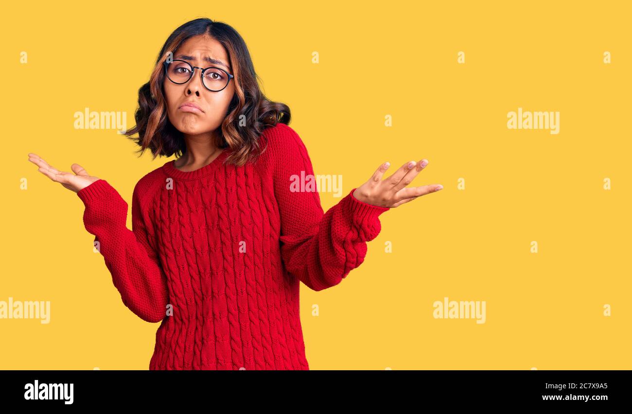 Young beautiful mixed race woman wearing red sweater and glasses ...