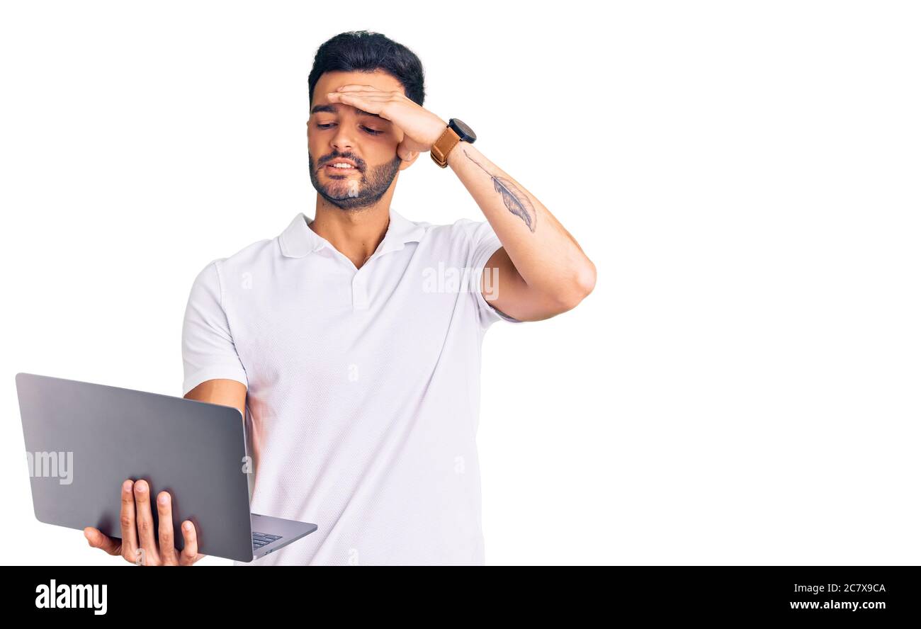 Young handsome hispanic man working using computer laptop stressed and ...