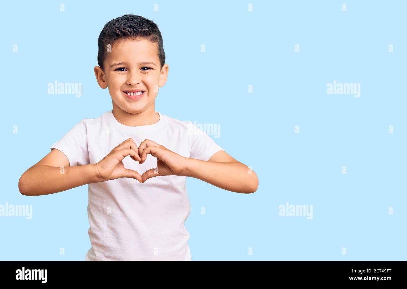Little cute boy kid wearing casual white tshirt smiling in love showing ...
