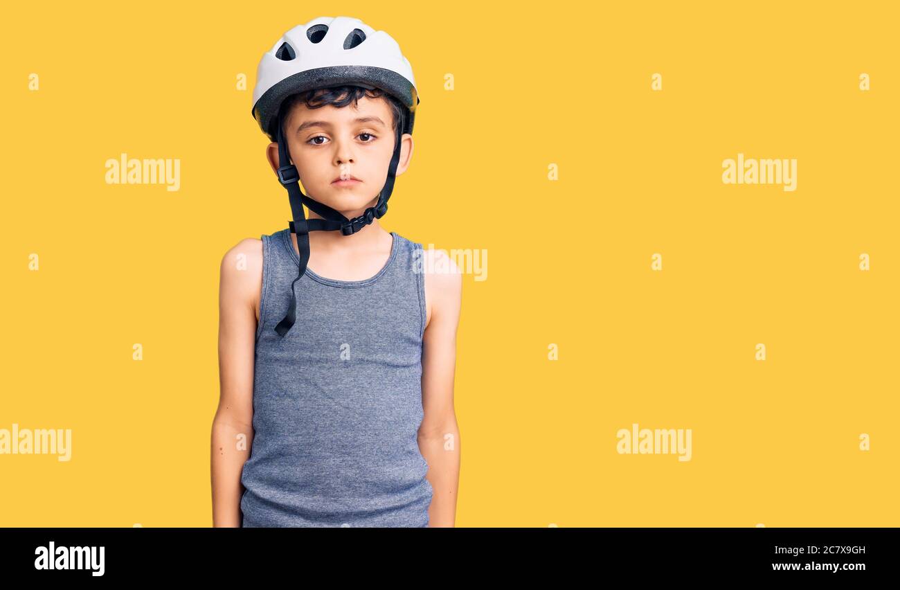 Little cute boy kid wearing bike helmet with serious expression on face ...