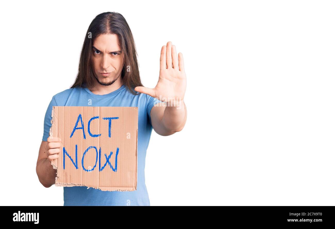 Young adult man with long hair holding act now banner with open hand ...