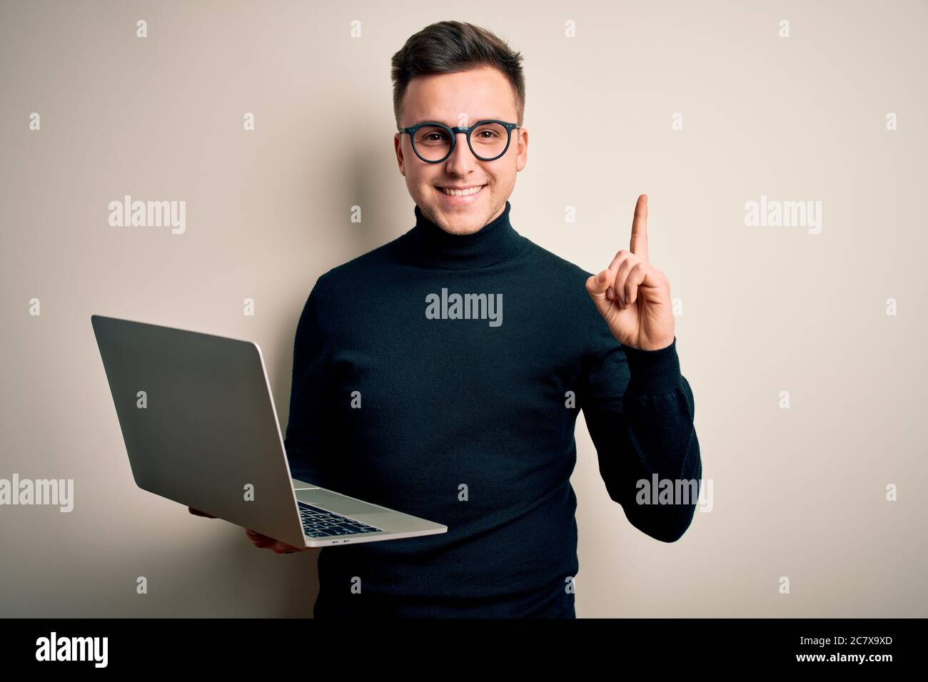 Young handsome caucasian business man wearing glasses using computer ...