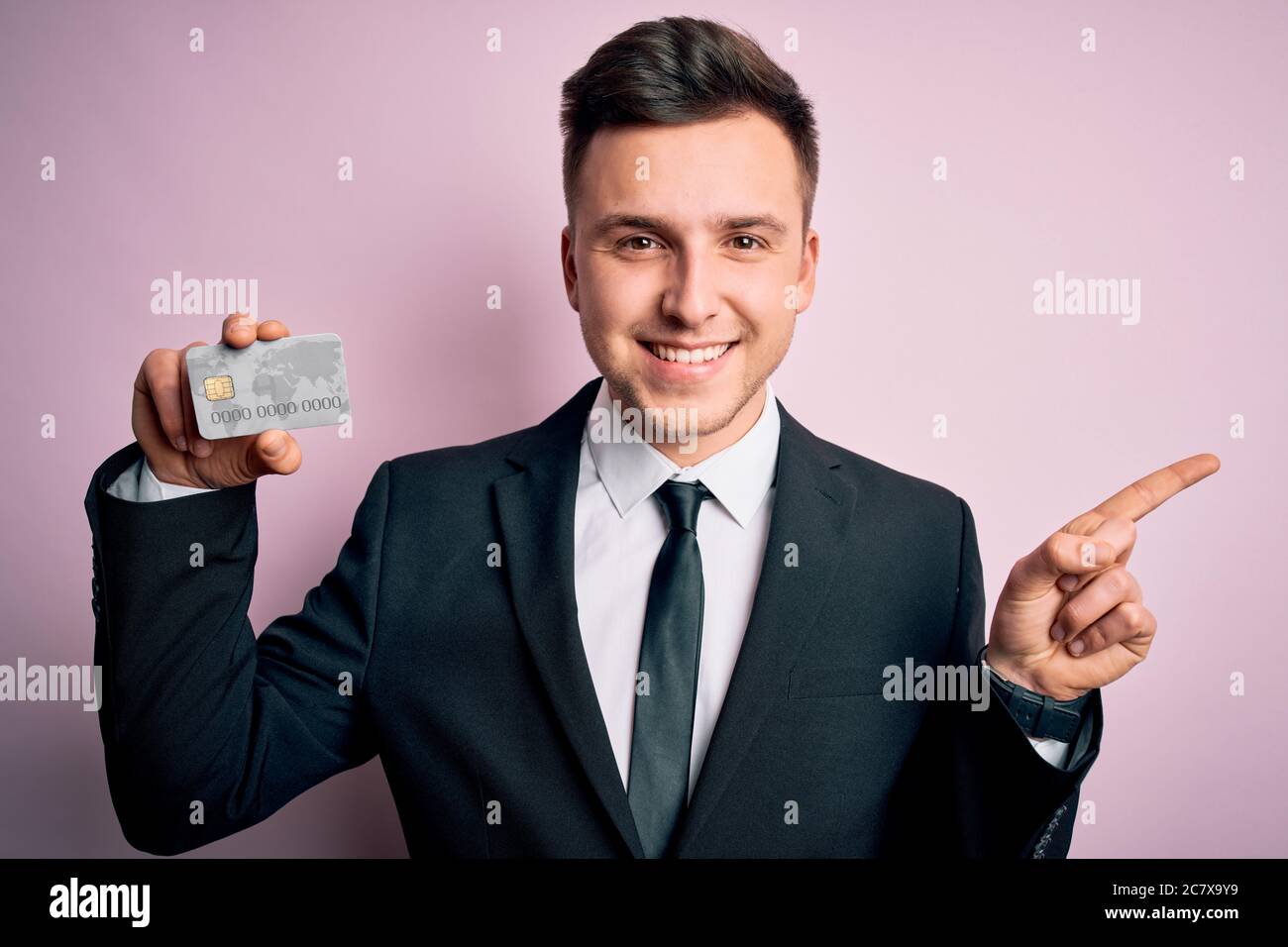 Young handsome caucasian business man holding finance credit card over ...
