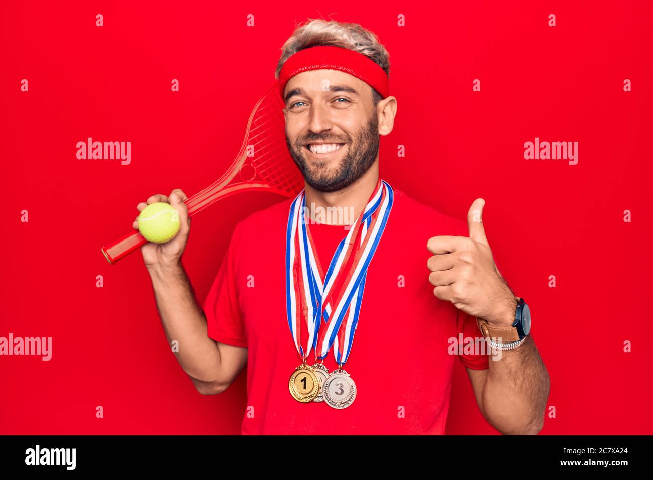 Handsome blond sportsman with beard winning medals playing tennis using ...