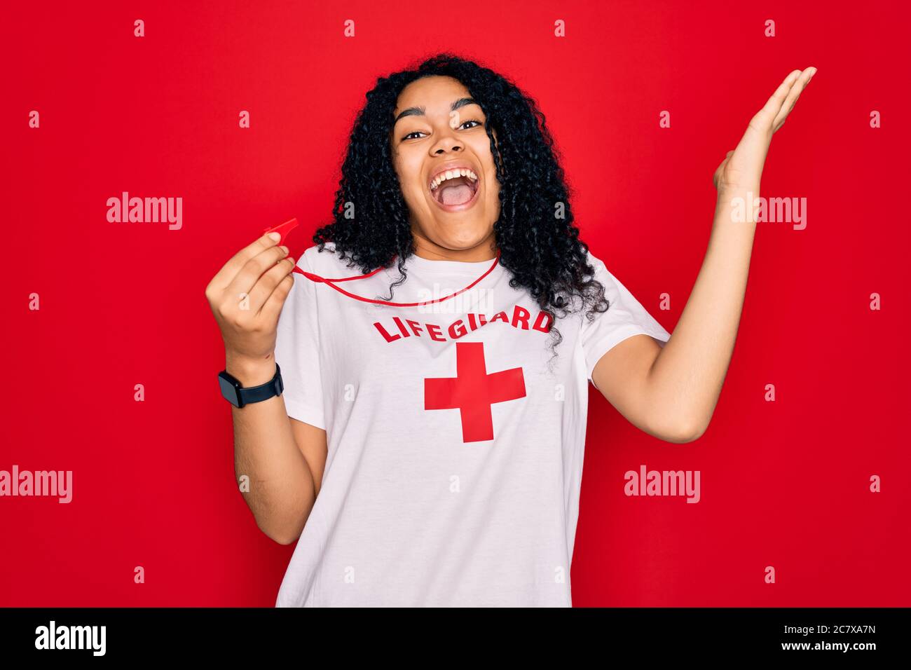 Young african american curly lifeguard woman wearing t-shirt with red ...