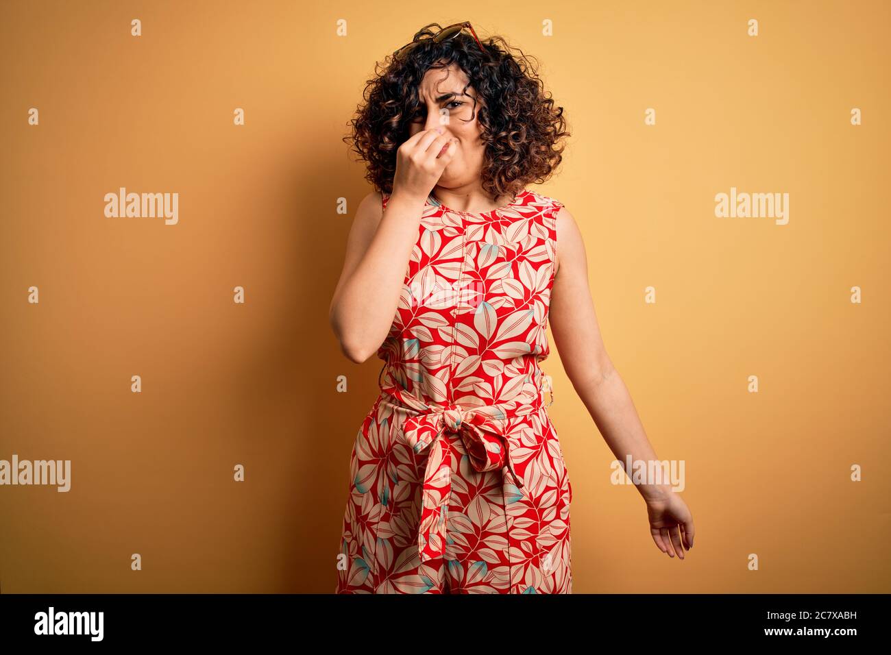 Young beautiful curly arab woman on vacation wearing summer floral ...