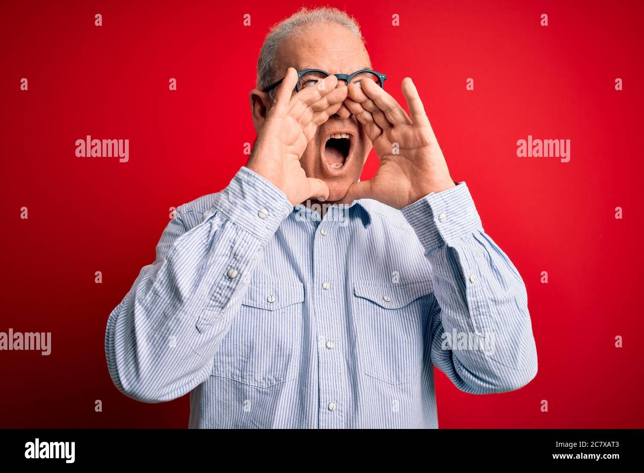 Middle age handsome hoary man wearing casual striped shirt and glasses ...
