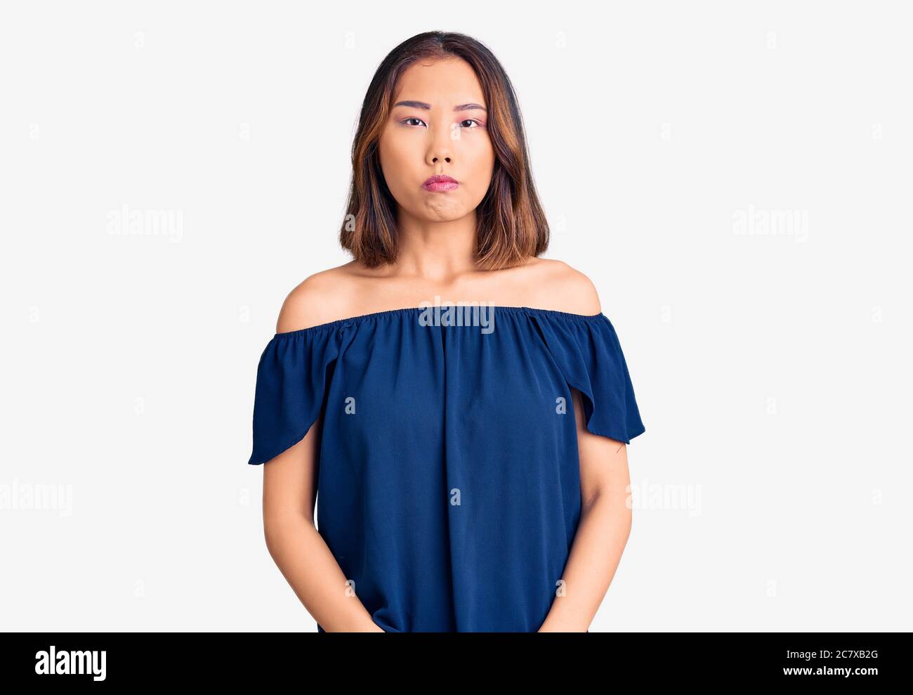 Young beautiful chinese girl wearing casual clothes depressed and worry ...