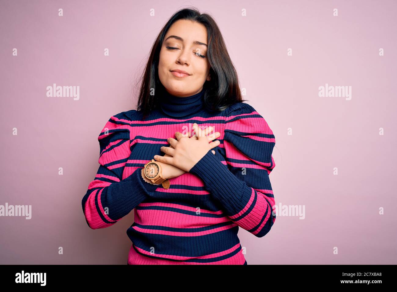 Young Brunette Elegant Woman Wearing Striped Shirt Over Pink Isolated