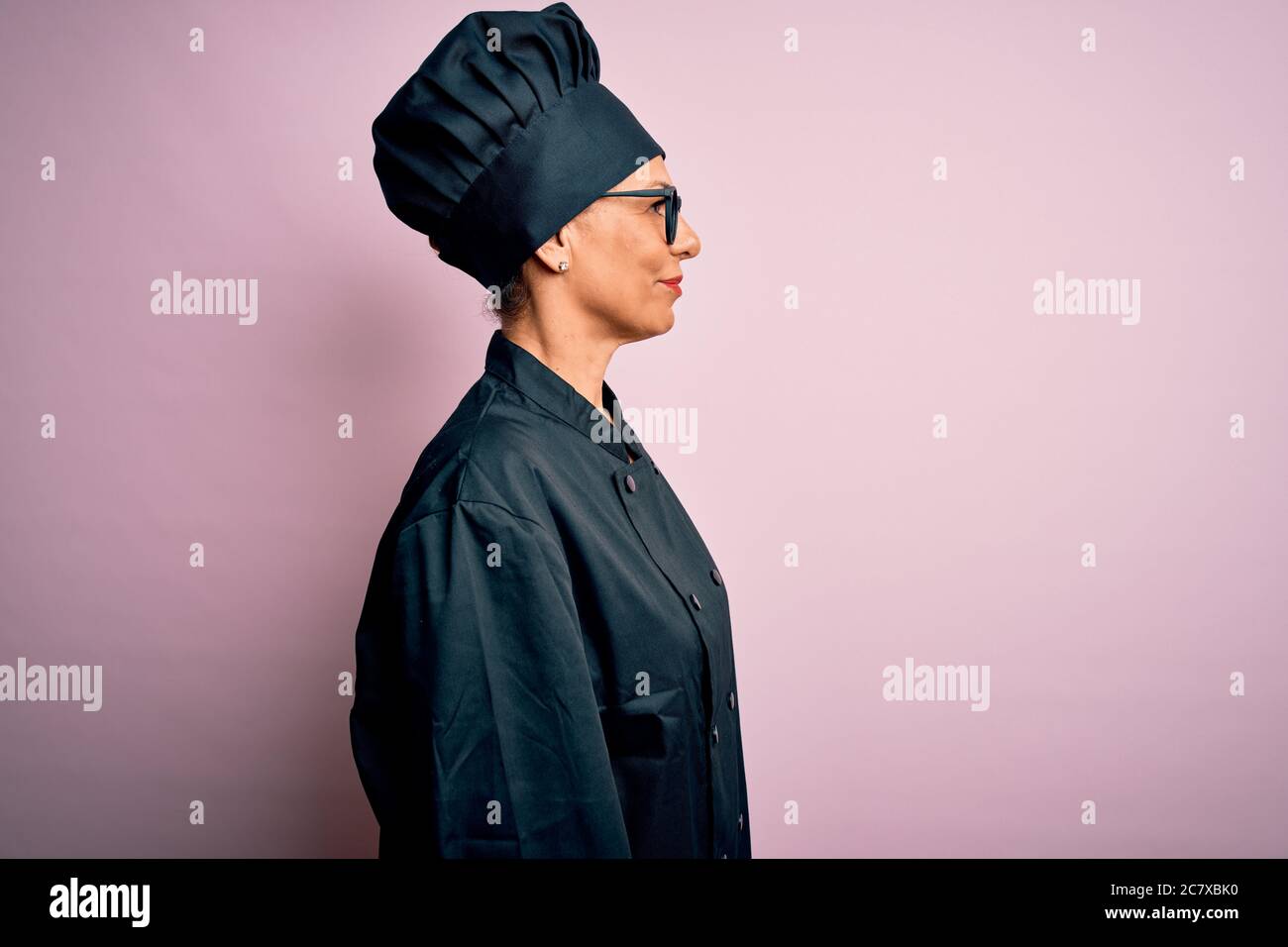 Middle age brunette chef woman wearing cooker uniform and hat over ...