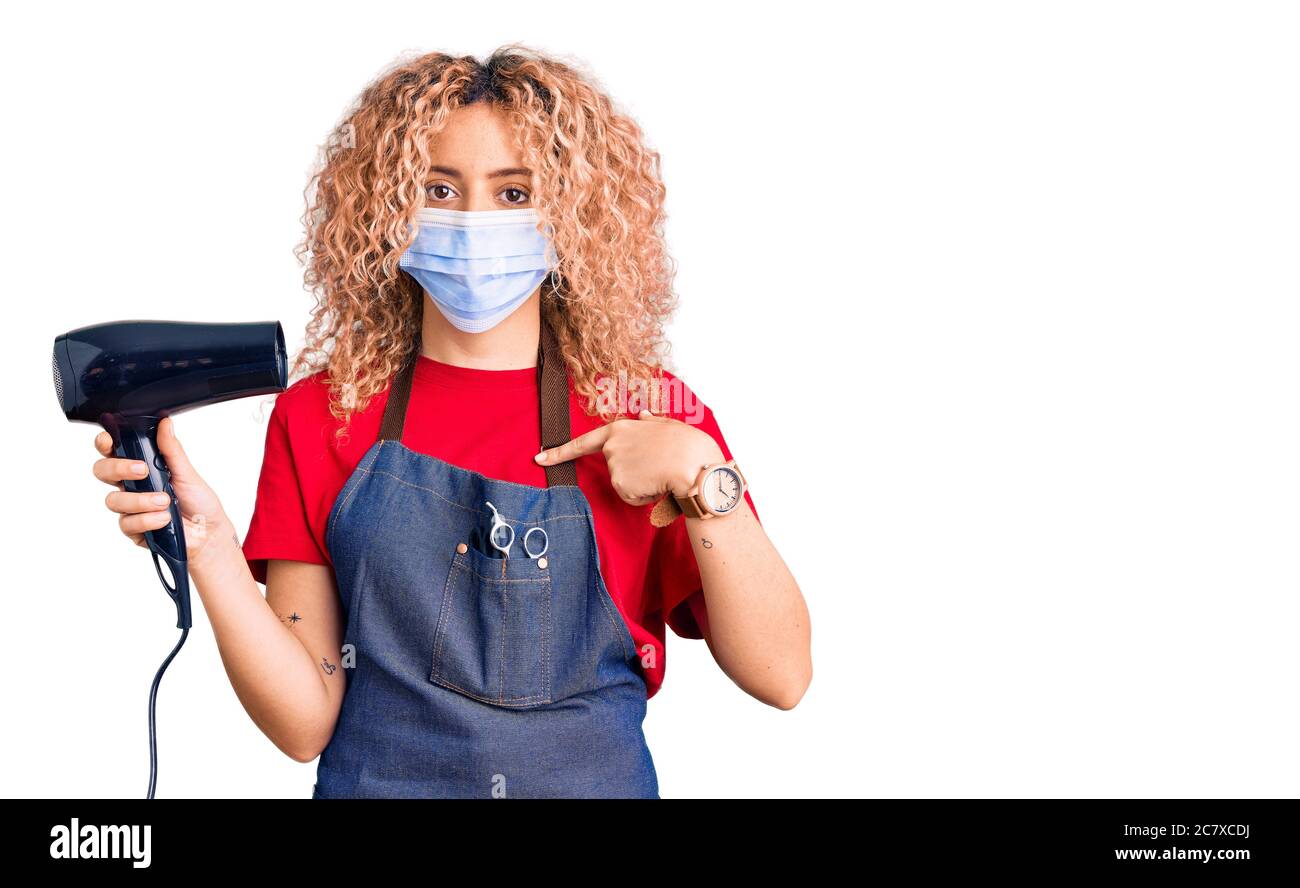 Young blonde woman with curly hair holding dryer blow wearing safety ...