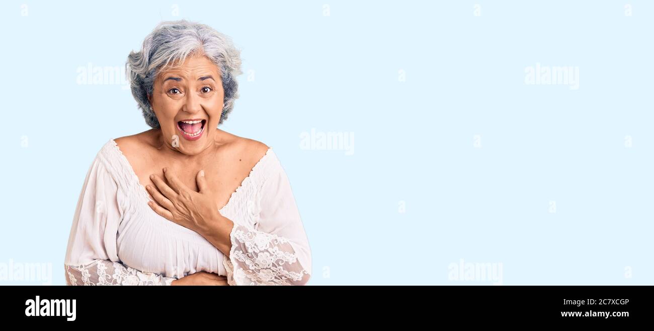 Senior woman with gray hair wearing bohemian style smiling and laughing ...