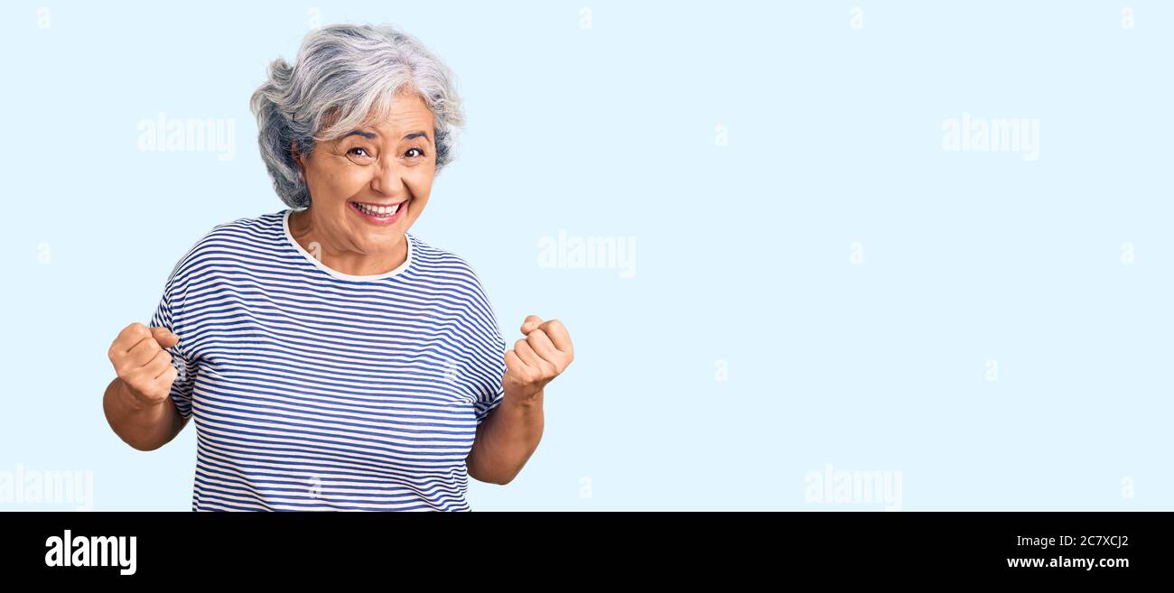 Senior woman with gray hair wearing casual striped clothes very happy ...