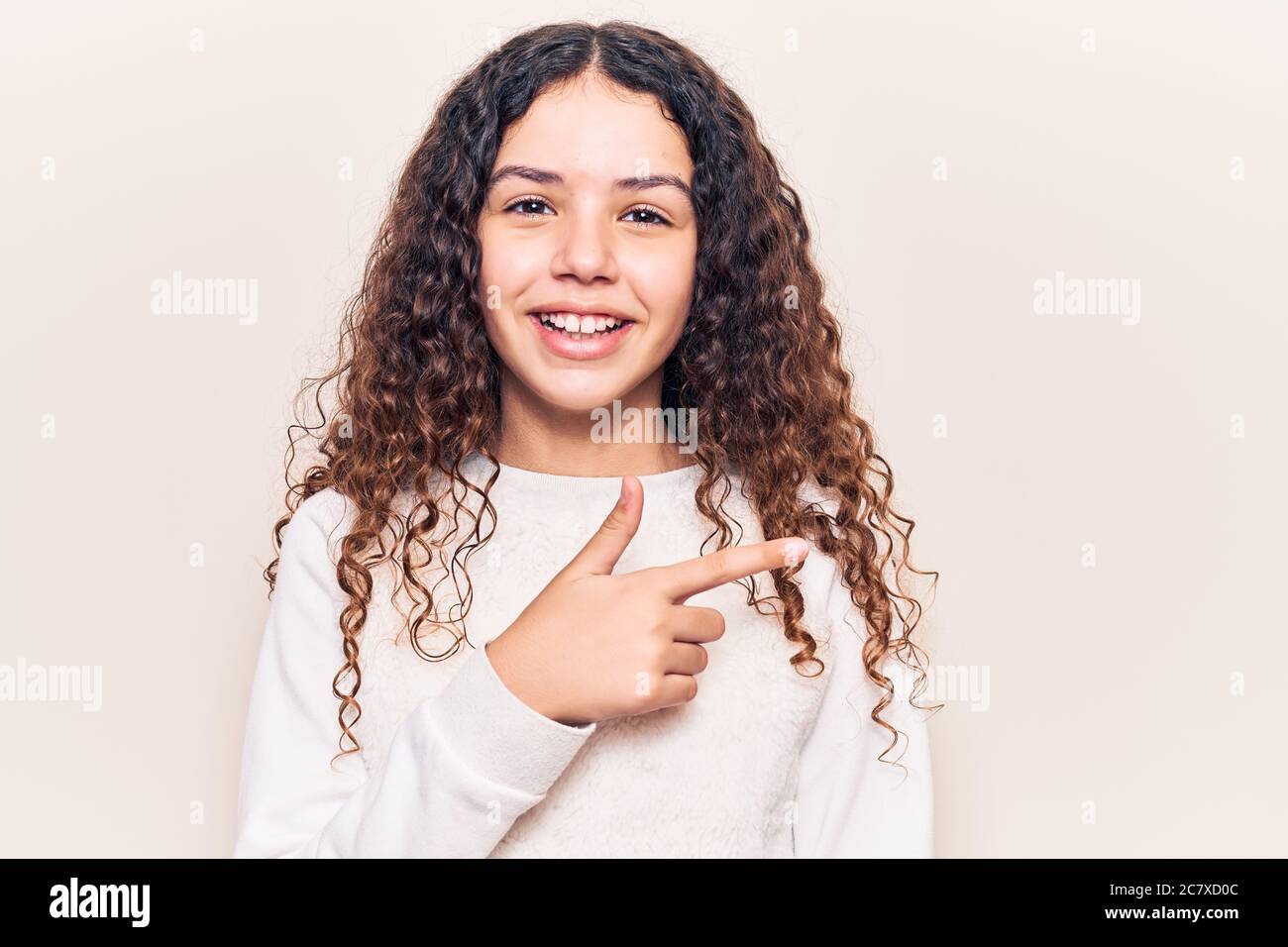 Beautiful kid girl with curly hair wearing casual clothes smiling ...