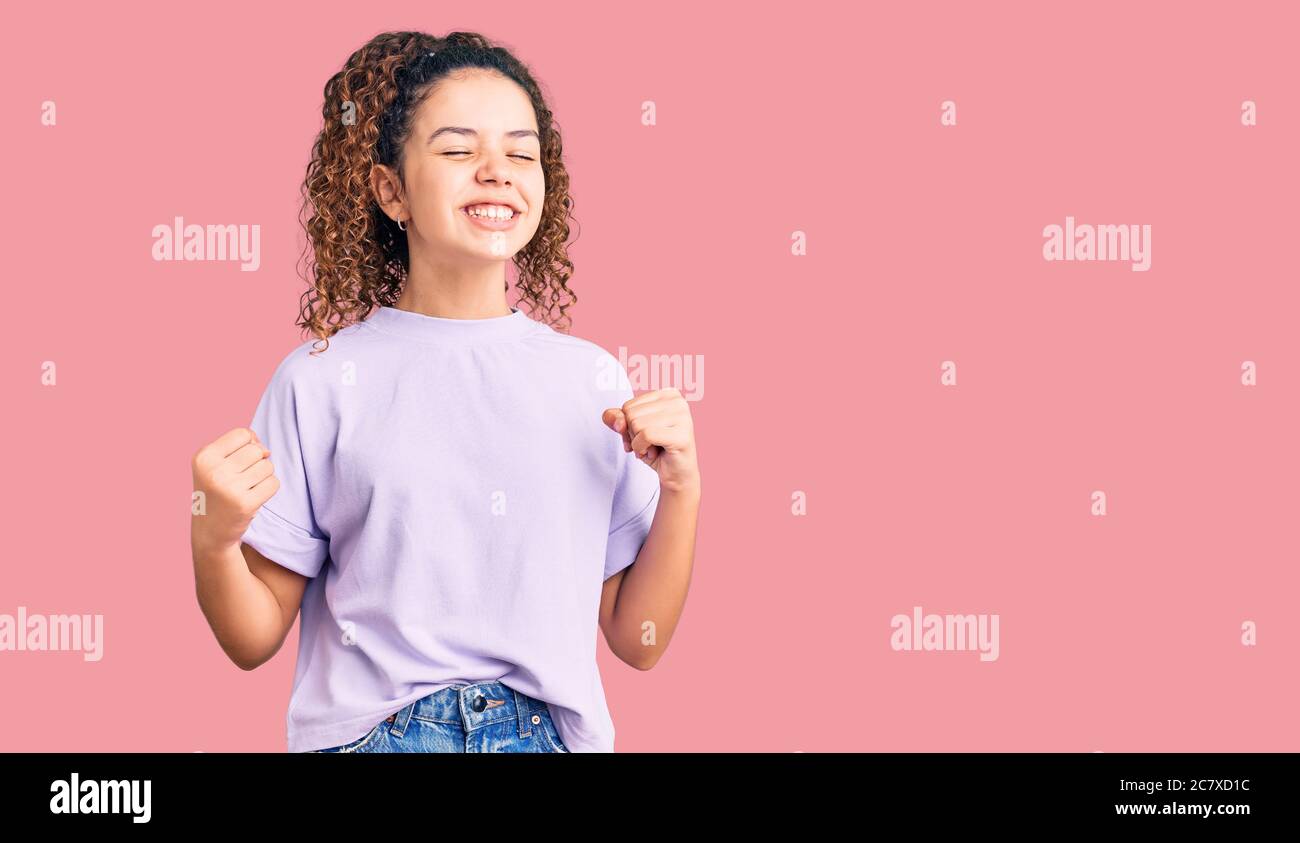 Beautiful kid girl with curly hair wearing casual clothes very happy ...