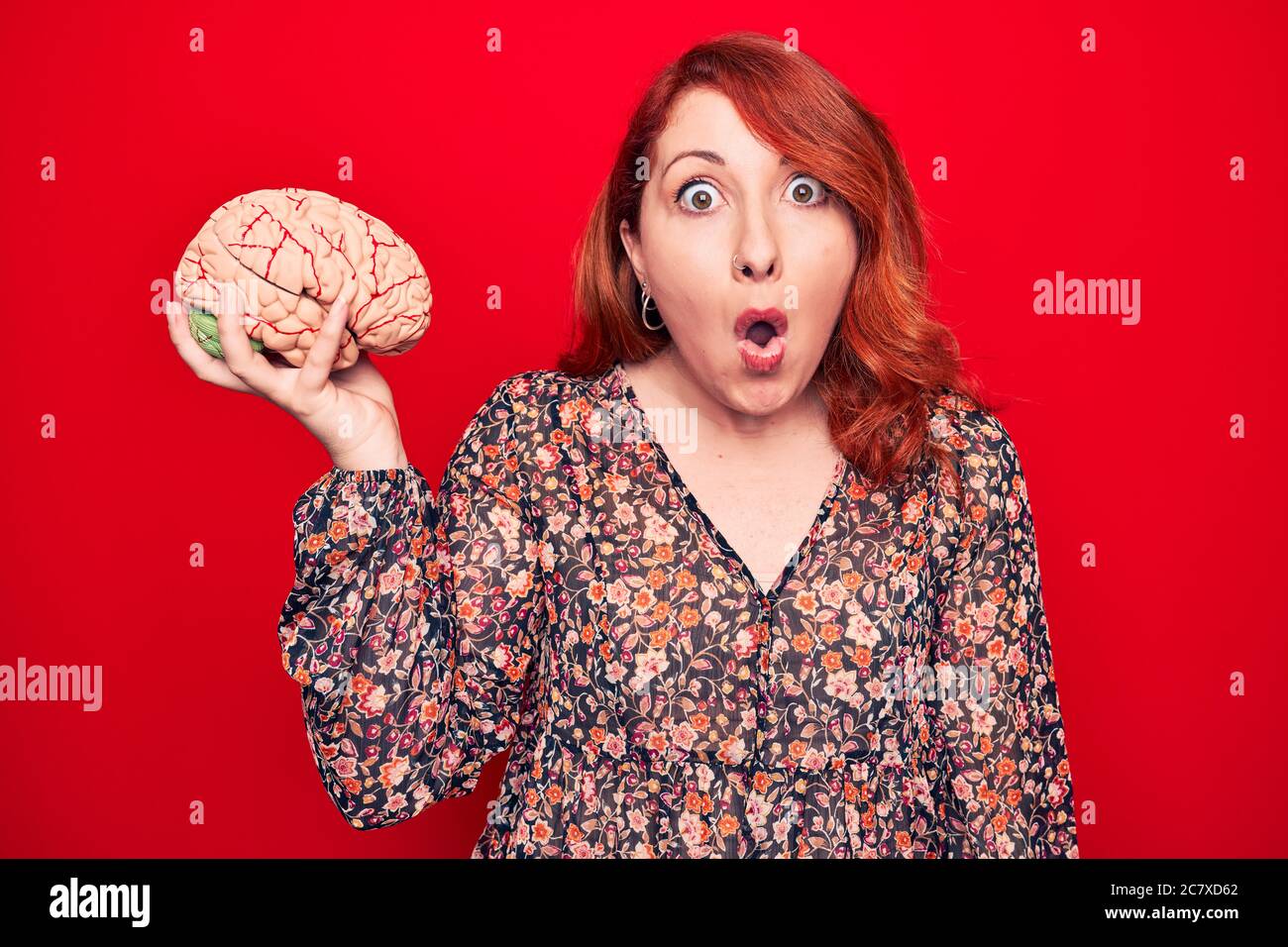 Young beautiful redhead woman asking for care memory holding brain over ...