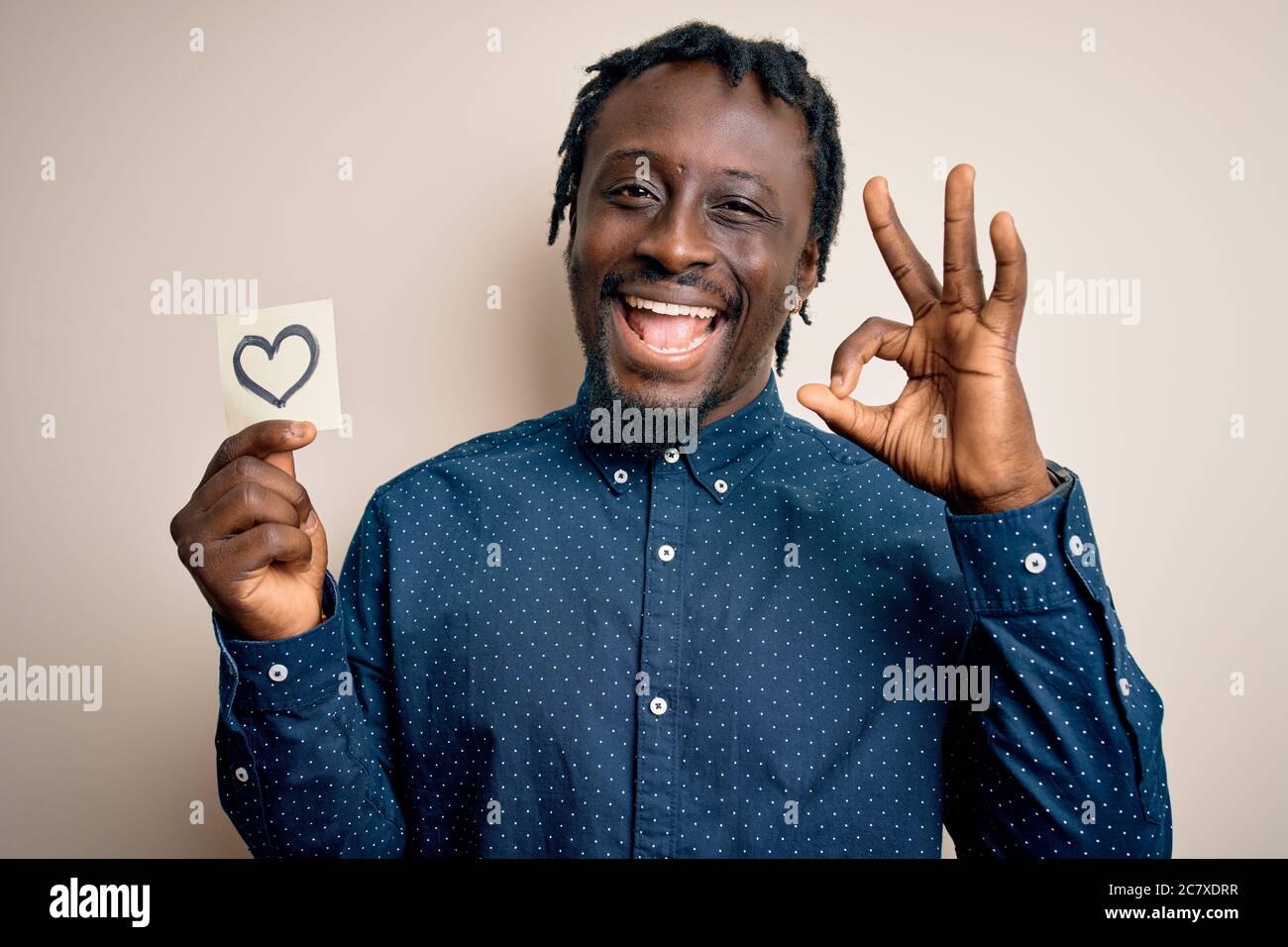 African american romantic man holding reminder with heart symbol over ...