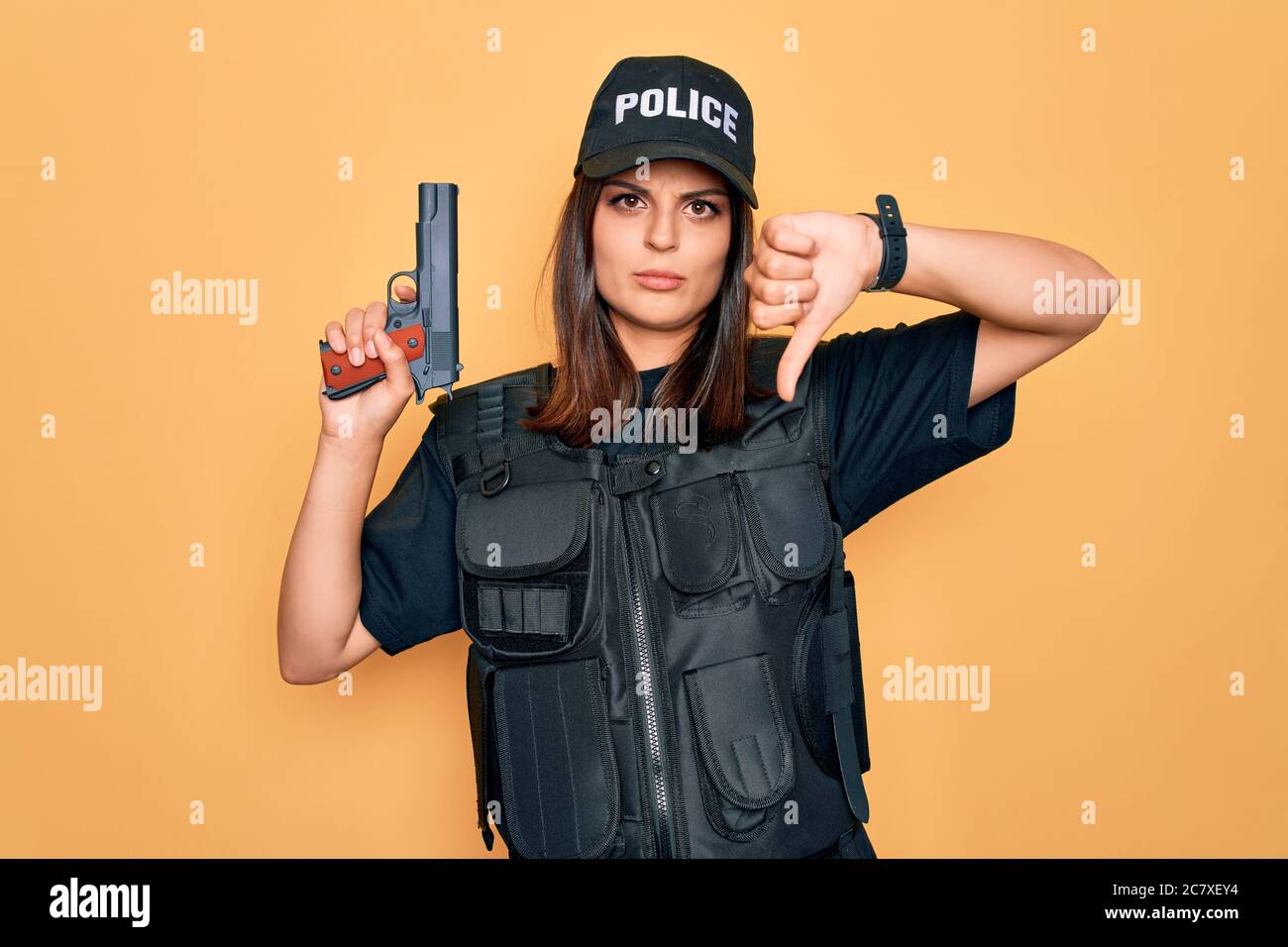 Young beautiful brunette policewoman wearing police uniform bulletproof ...