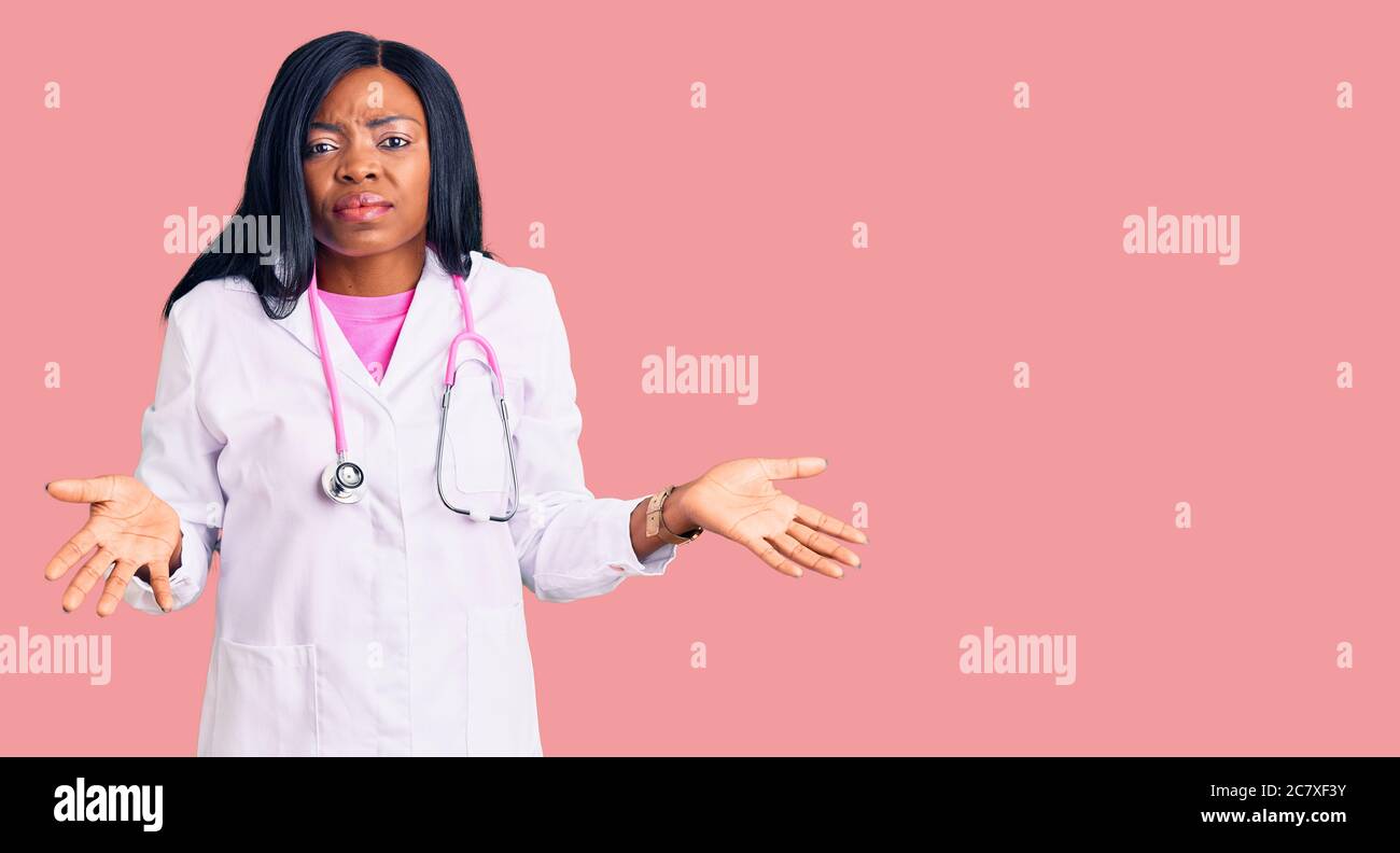 Young african american woman wearing doctor stethoscope clueless and ...