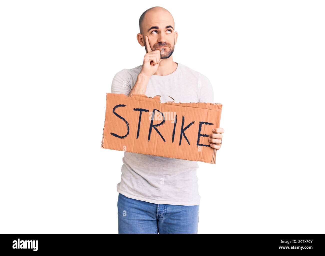 Young handsome man holding strike banner serious face thinking about ...