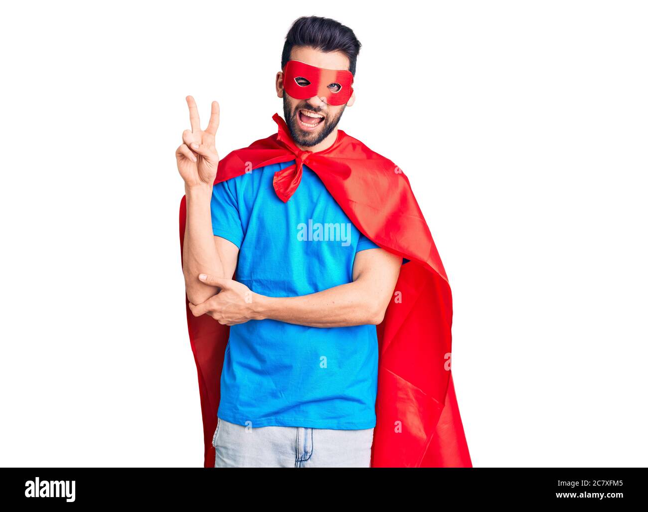 Young handsome man with beard wearing super hero costume smiling with ...
