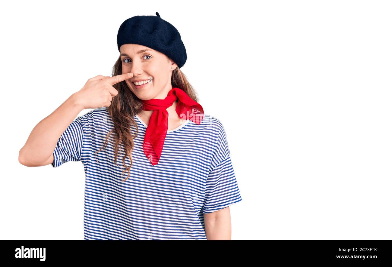 Young beautiful blonde woman wearing french beret and striped t-shirt ...