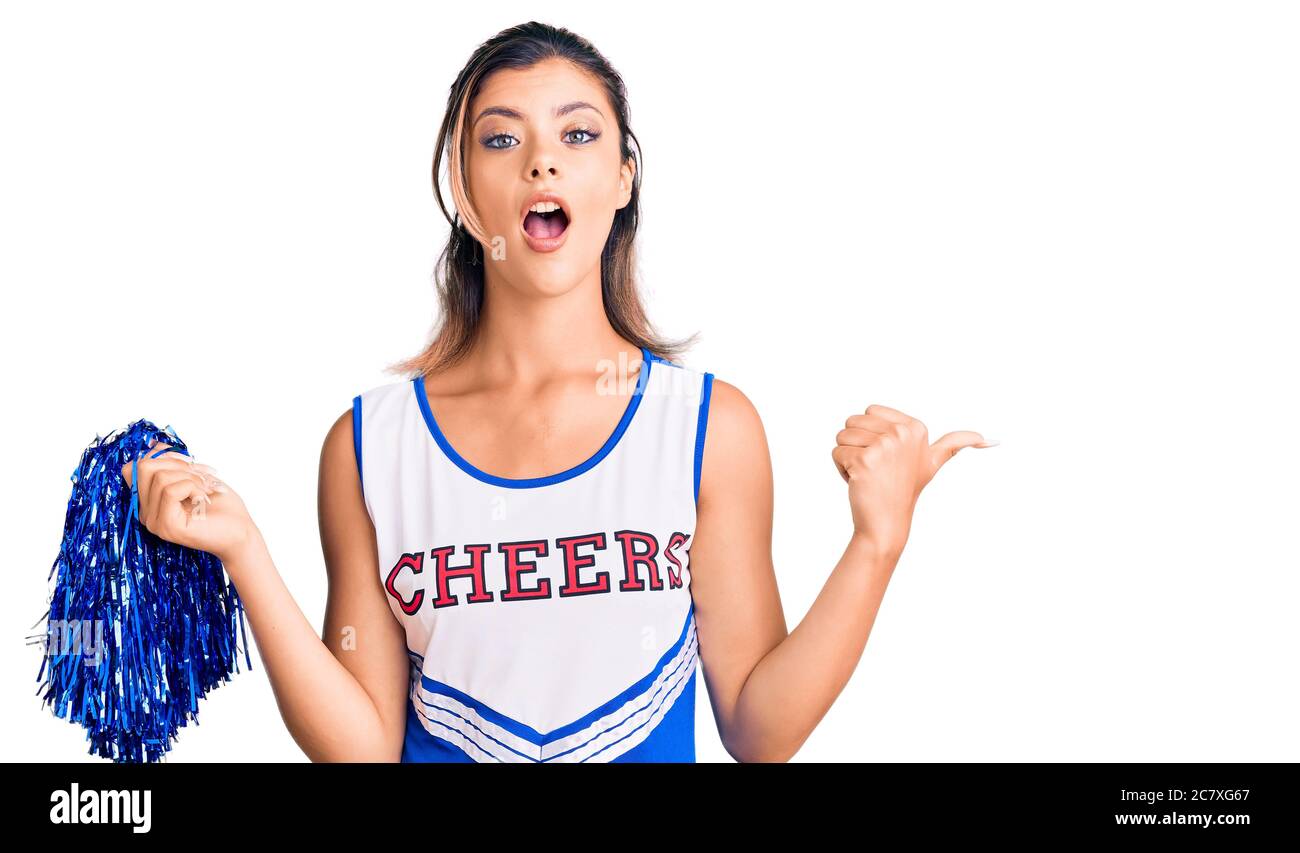 Young Beautiful Woman Wearing Cheerleader Uniform Surprised Pointing