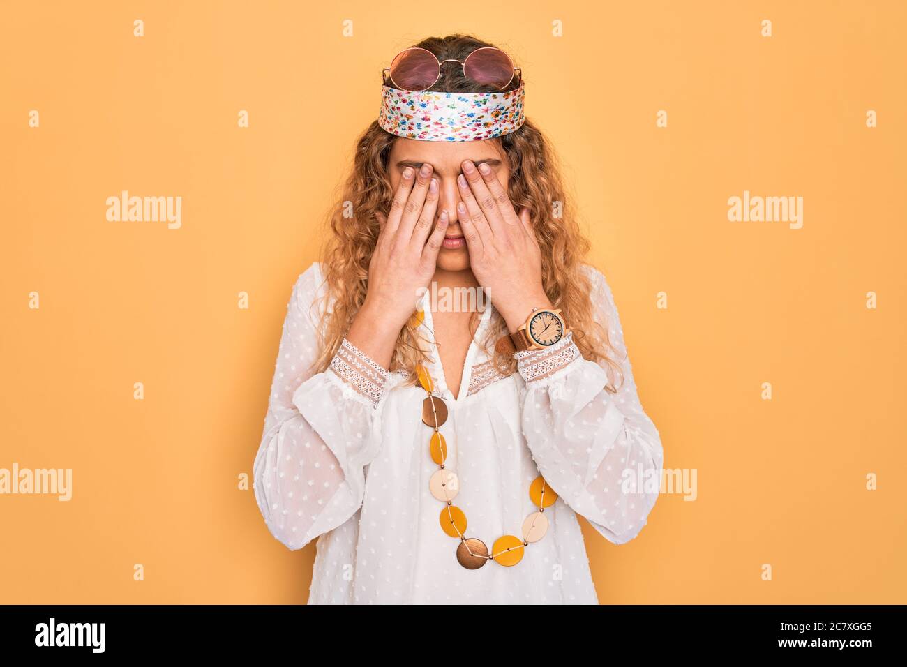 Young beautiful blonde hippie woman with blue eyes wearing sunglasses ...