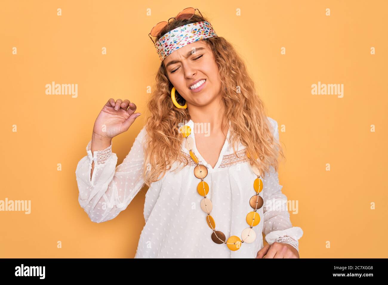 Young beautiful blonde hippie woman with blue eyes wearing sunglasses ...