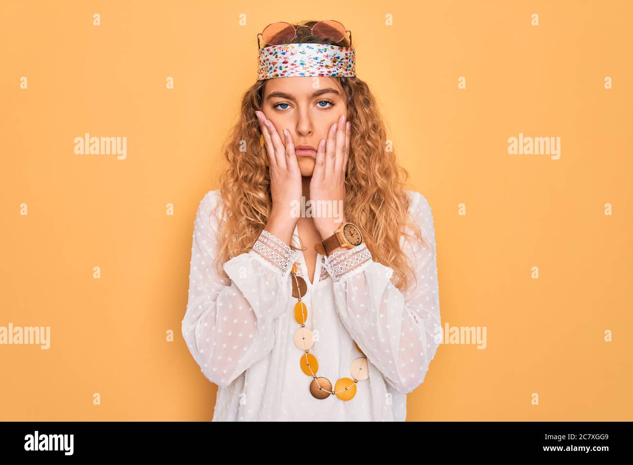 Young beautiful blonde hippie woman with blue eyes wearing sunglasses ...