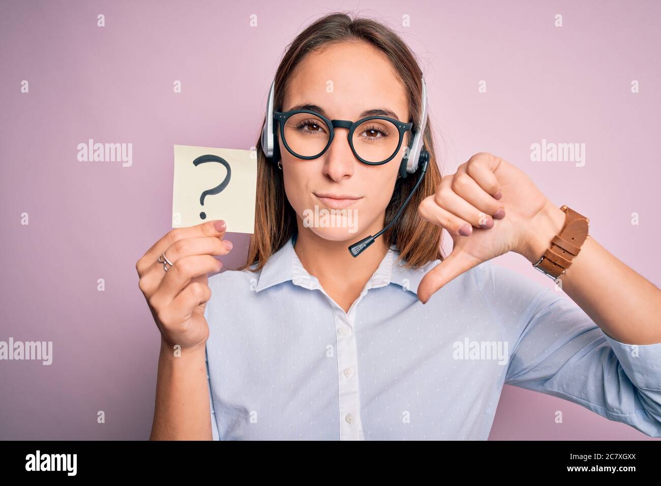 Beautiful call center agent woman working using headset holding ...