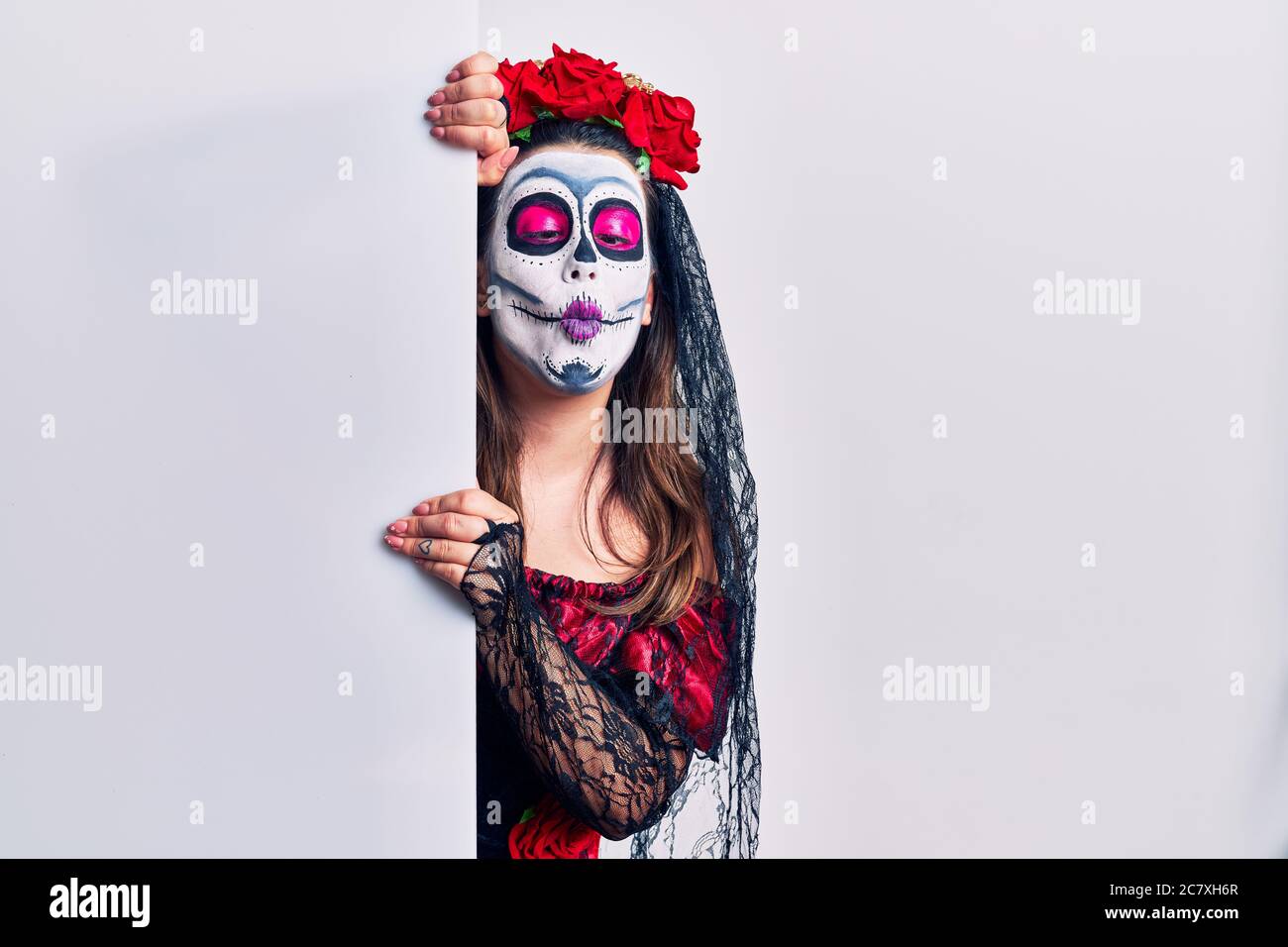 Young woman wearing day of the dead custome holding blank empty banner ...