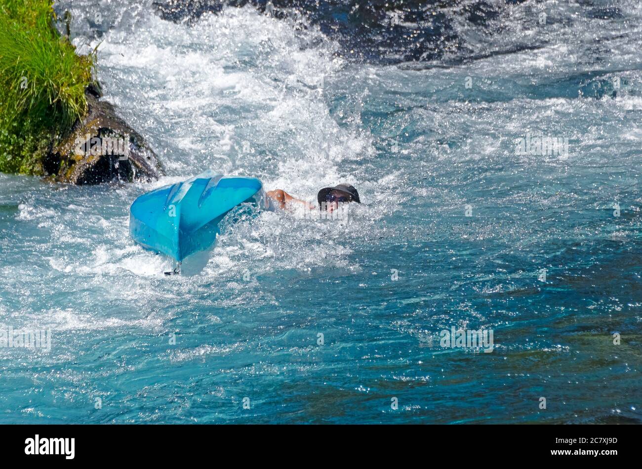 Kayak tipping over while going over the rapids Stock Photo - Alamy