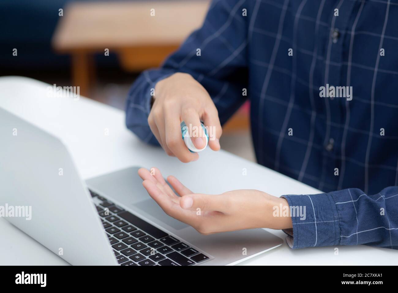 Hand of man work from home with alcohol gel or sanitizer for cleaning ...