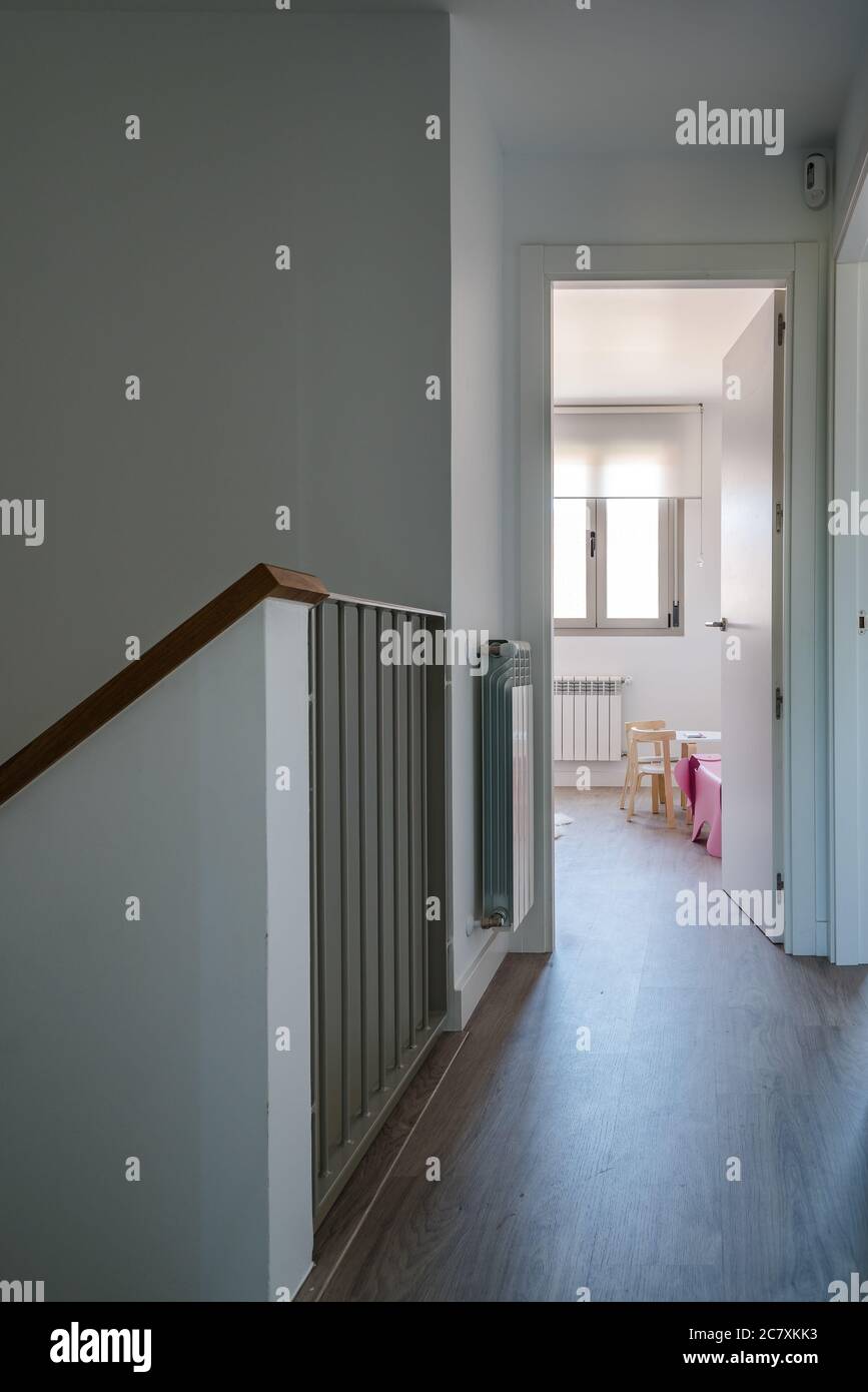 Vertical shot of a hallway leading to a room with white walls under the ...