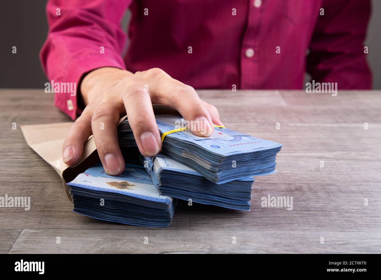 Closeup of a hand on a pile of money - Hush money concept Stock Photo ...