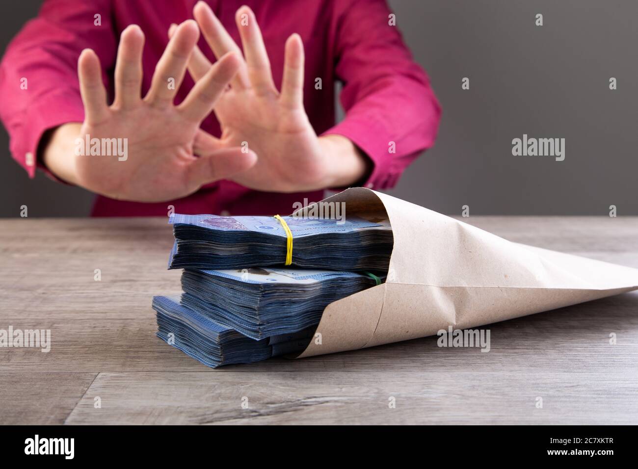 Picture of a hand rejecting a pile of money - Hush money concept Stock ...