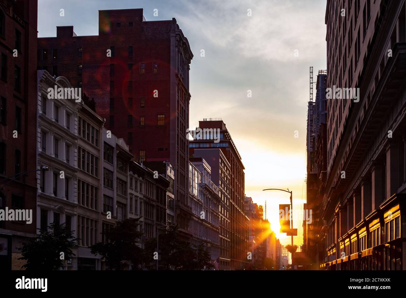 Light of sunset shines between the buildings along 23rd Street in ...