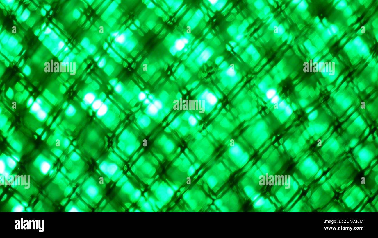Closeup shot of green lights shining through the chain link fence Stock ...
