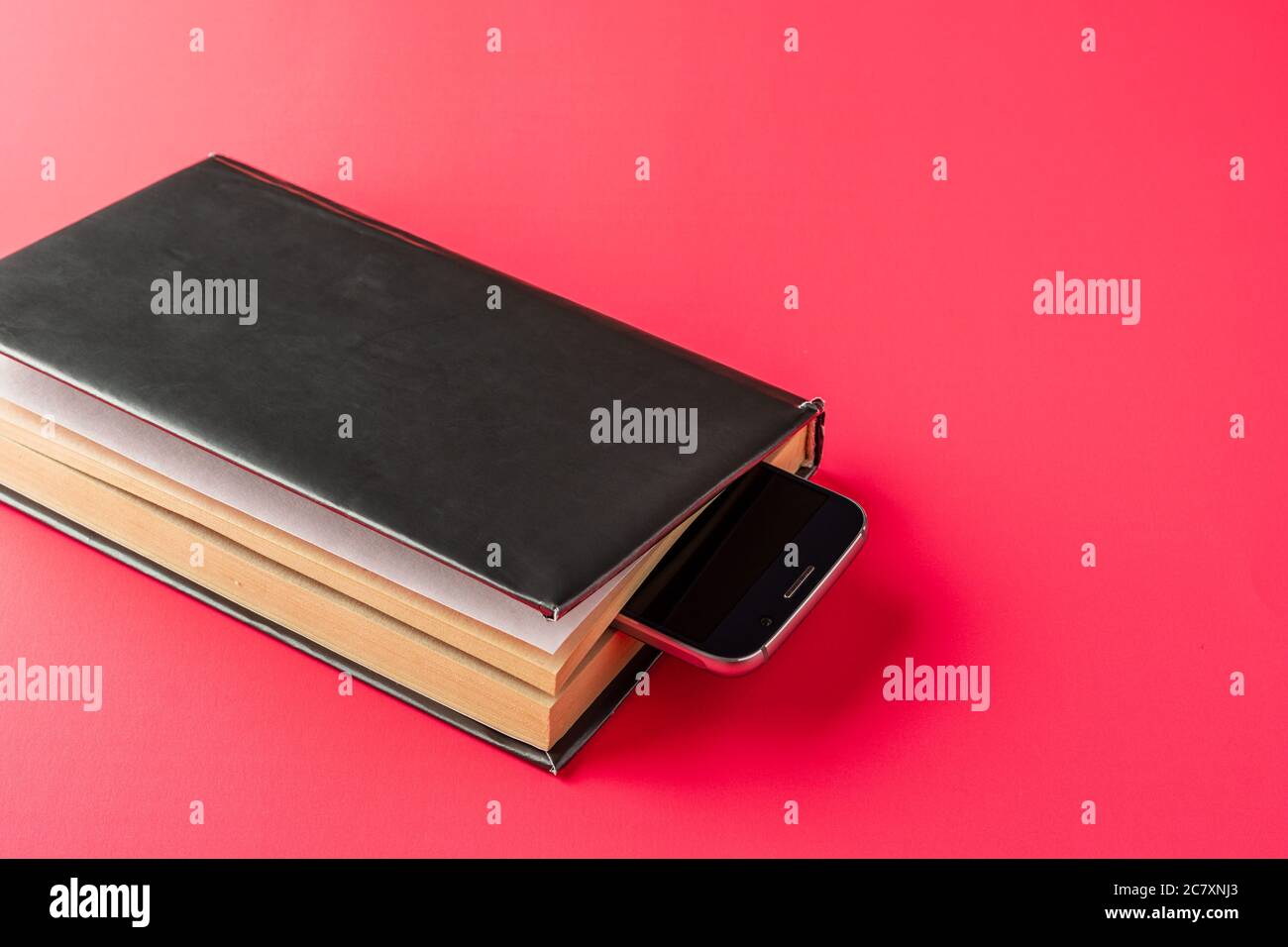 smartphone is used as bookmark in the book on pink background Stock ...