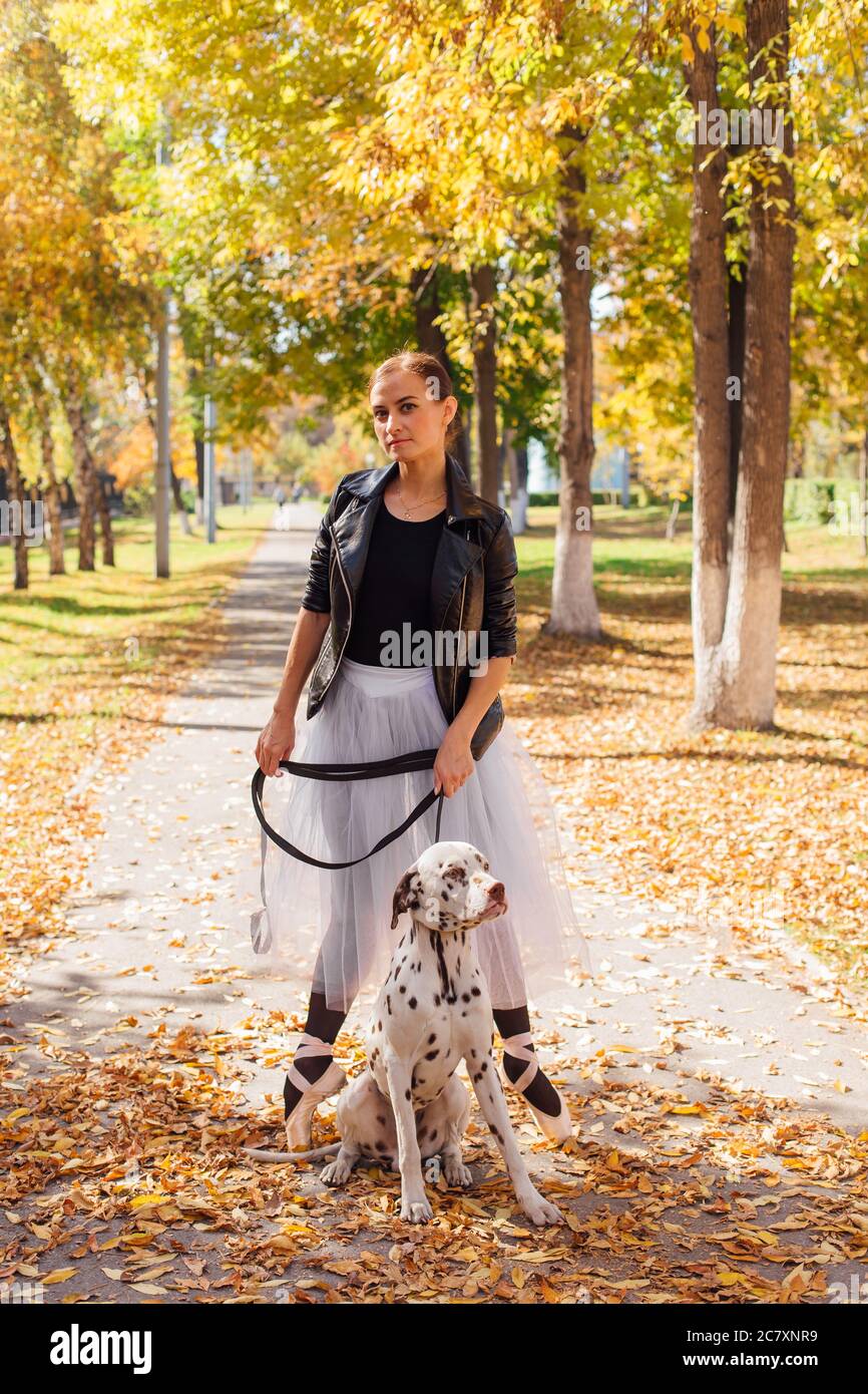 Ballerina with Dalmatian dog in the Park. Woman ballerina in a white ...
