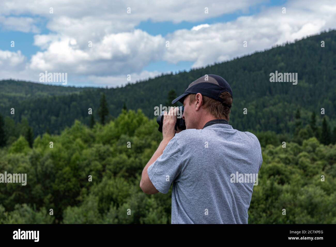 male photographer shoots a beautiful landscape, views of mountains and ...