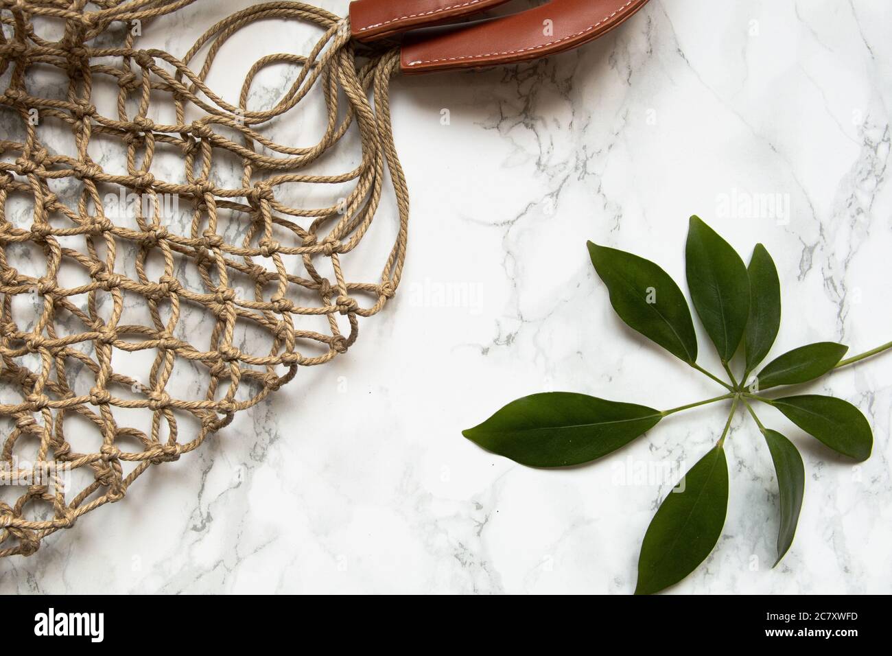 Eco flat lay with woven bag and plant Stock Photo - Alamy