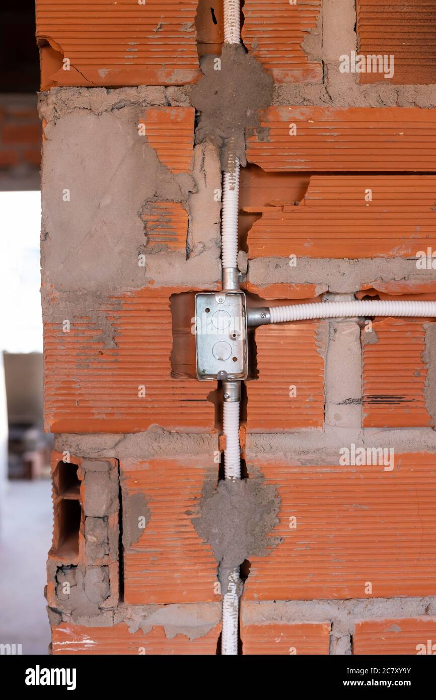 Vertical shot of electrical socket arrangement through a concrete wall ...