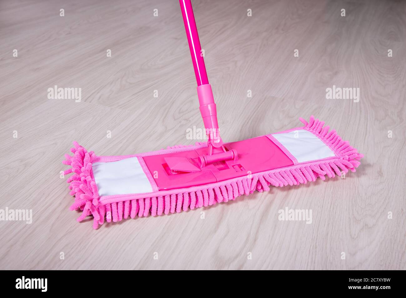 cleaning concept -close up of wooden floor with pink mop Stock Photo ...