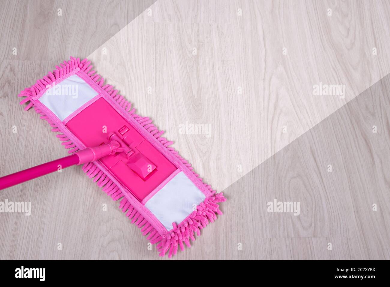 before and after cleaning concept - pink mop on wooden parquet floor ...
