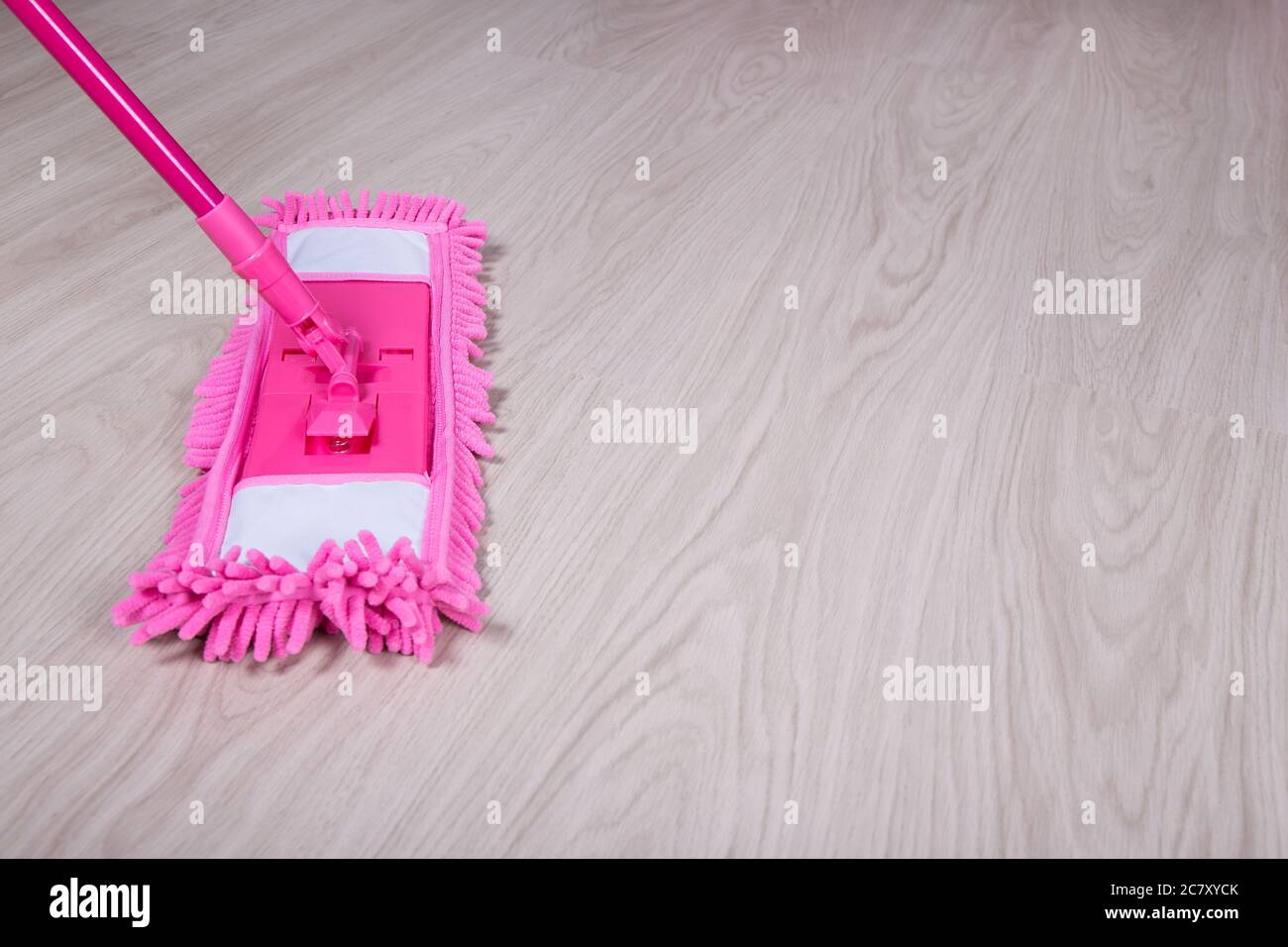 cleaning concept -close up of pink mop on wooden floor Stock Photo - Alamy