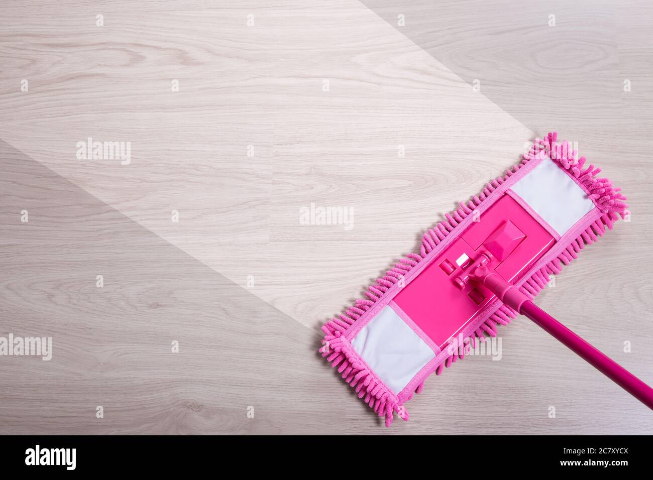 before and after cleaning concept - close up of pink floor mop on ...