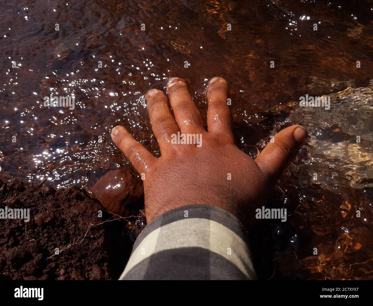 Hand touching stream water hi-res stock photography and images - Alamy