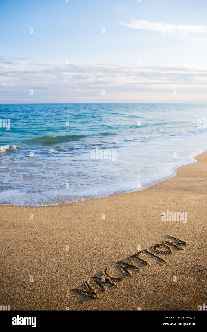 travel concept - beach background with word vacation written in sand ...